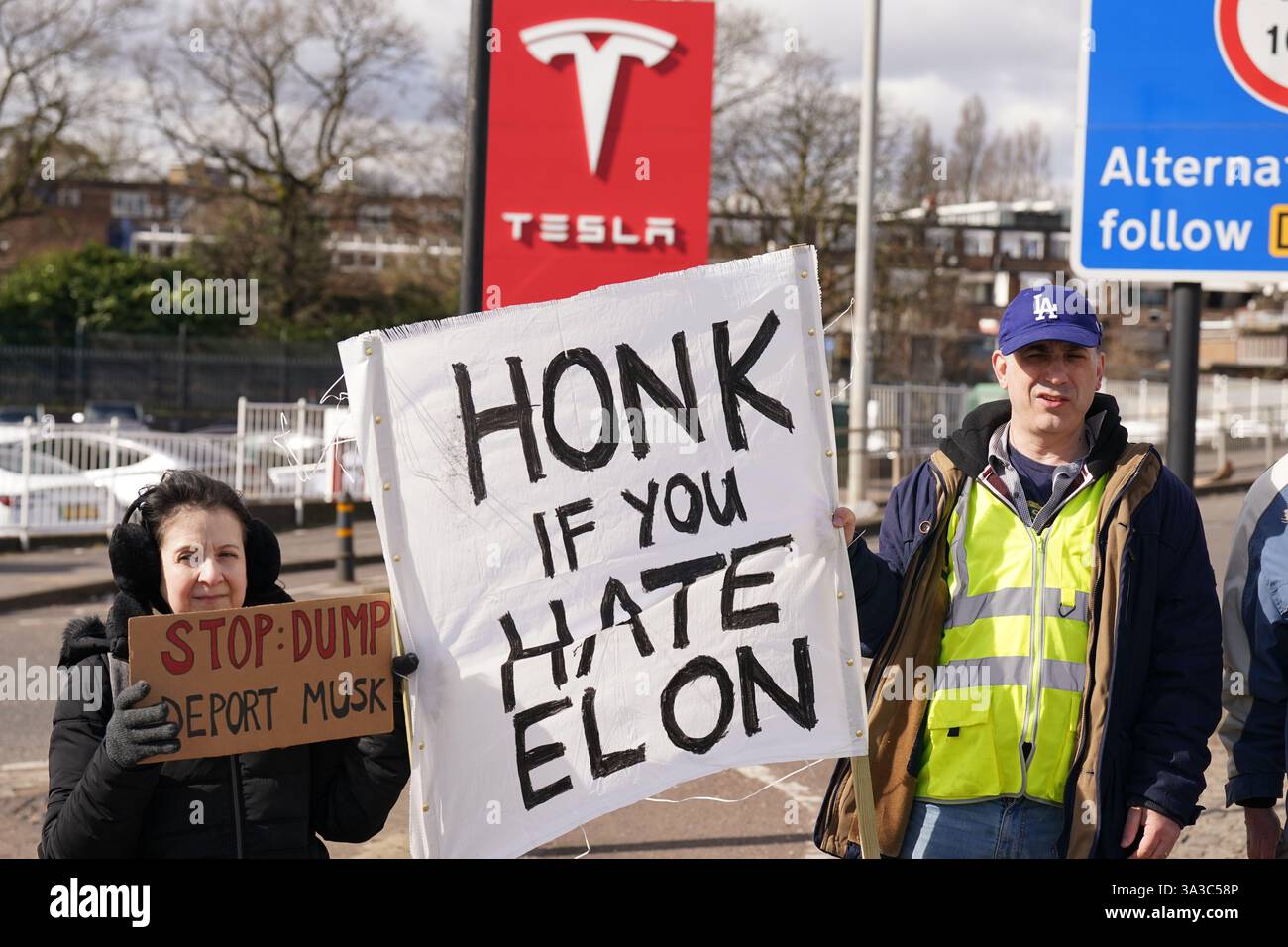 People take part in a protest outside of the Tesla centre at Park Royal ...