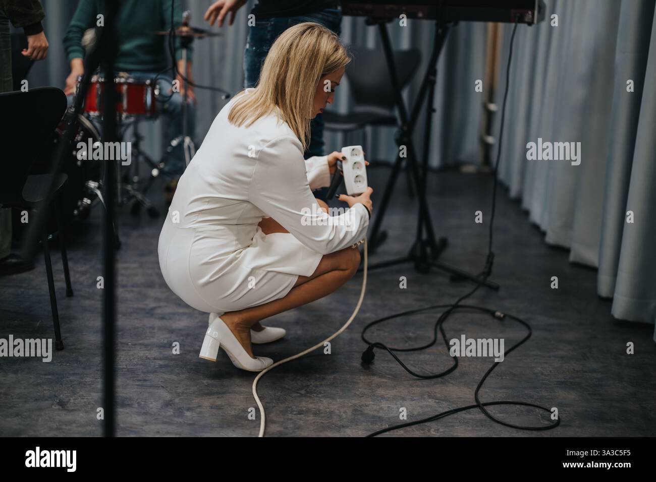 Woman setting up electrical connections during music rehearsal in ...