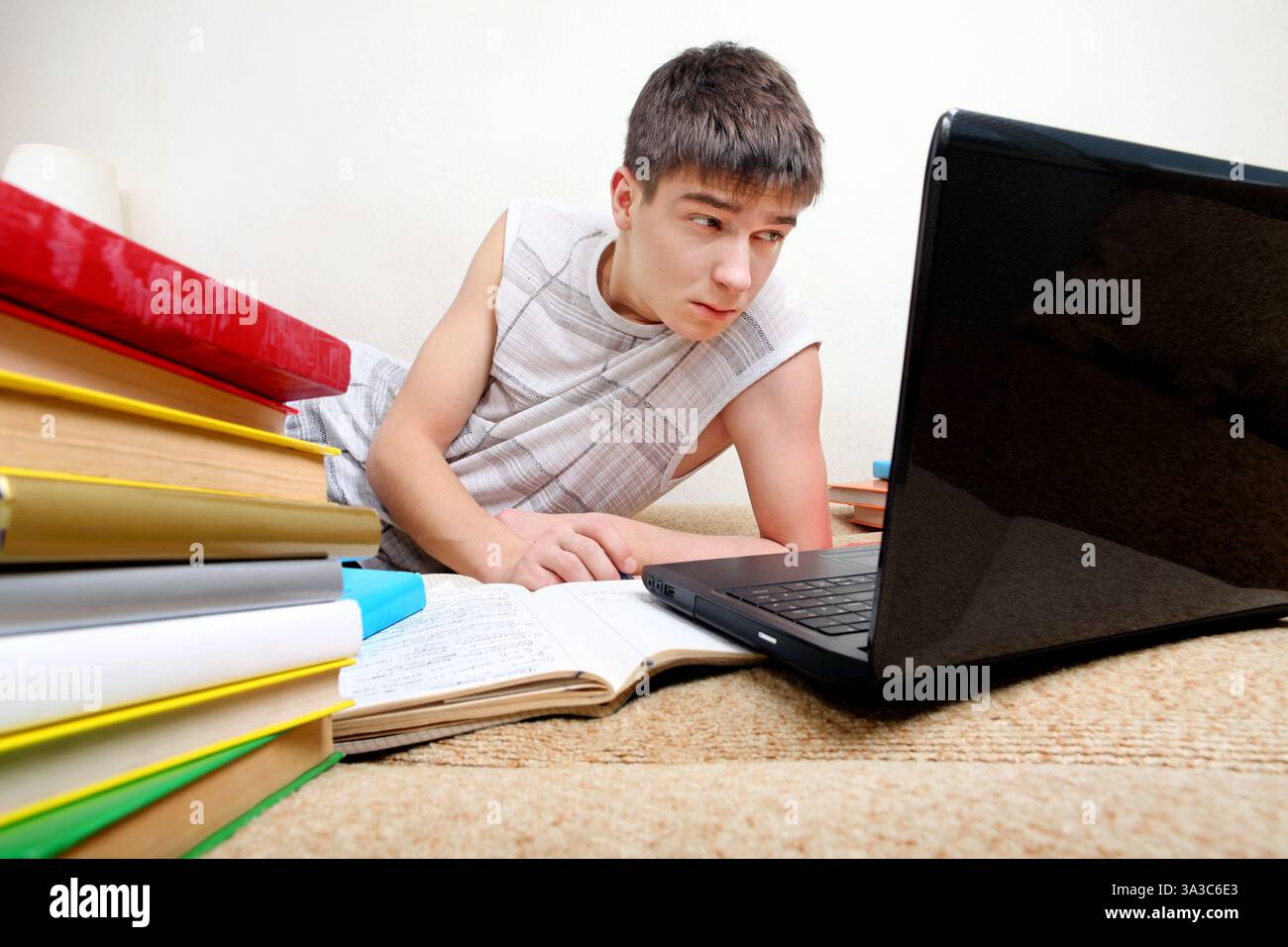Annoyed Teenager doing Homework at the Home Stock Photo - Alamy