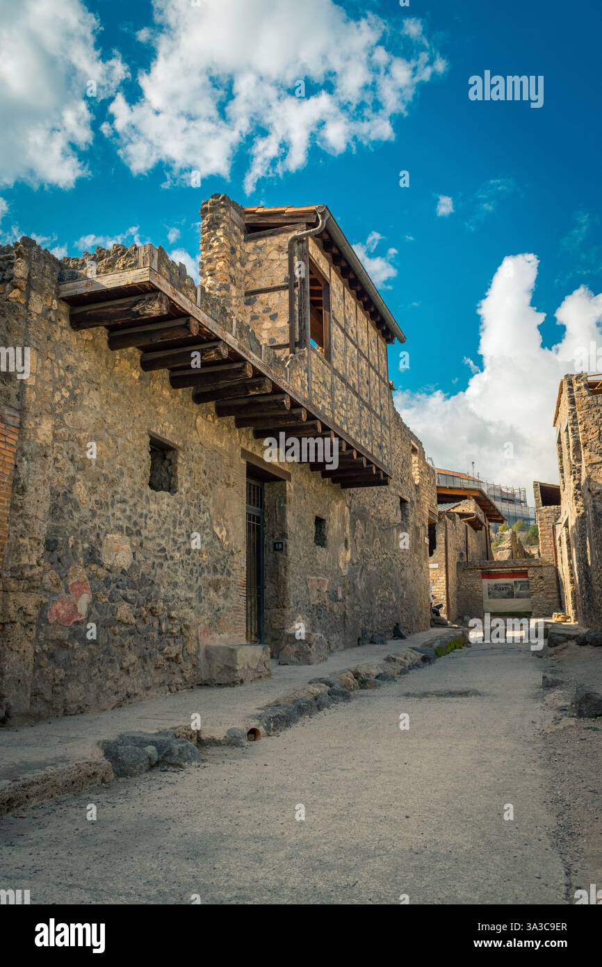 A historic cobblestone street with ancient stone houses in Pompeii ...