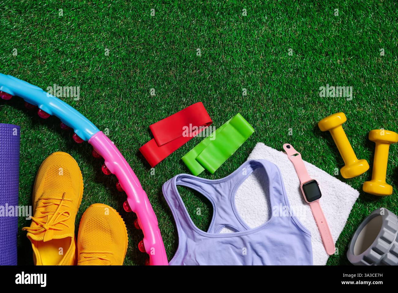 Different gym stuff and wrist watch on artificial green grass, flat lay ...