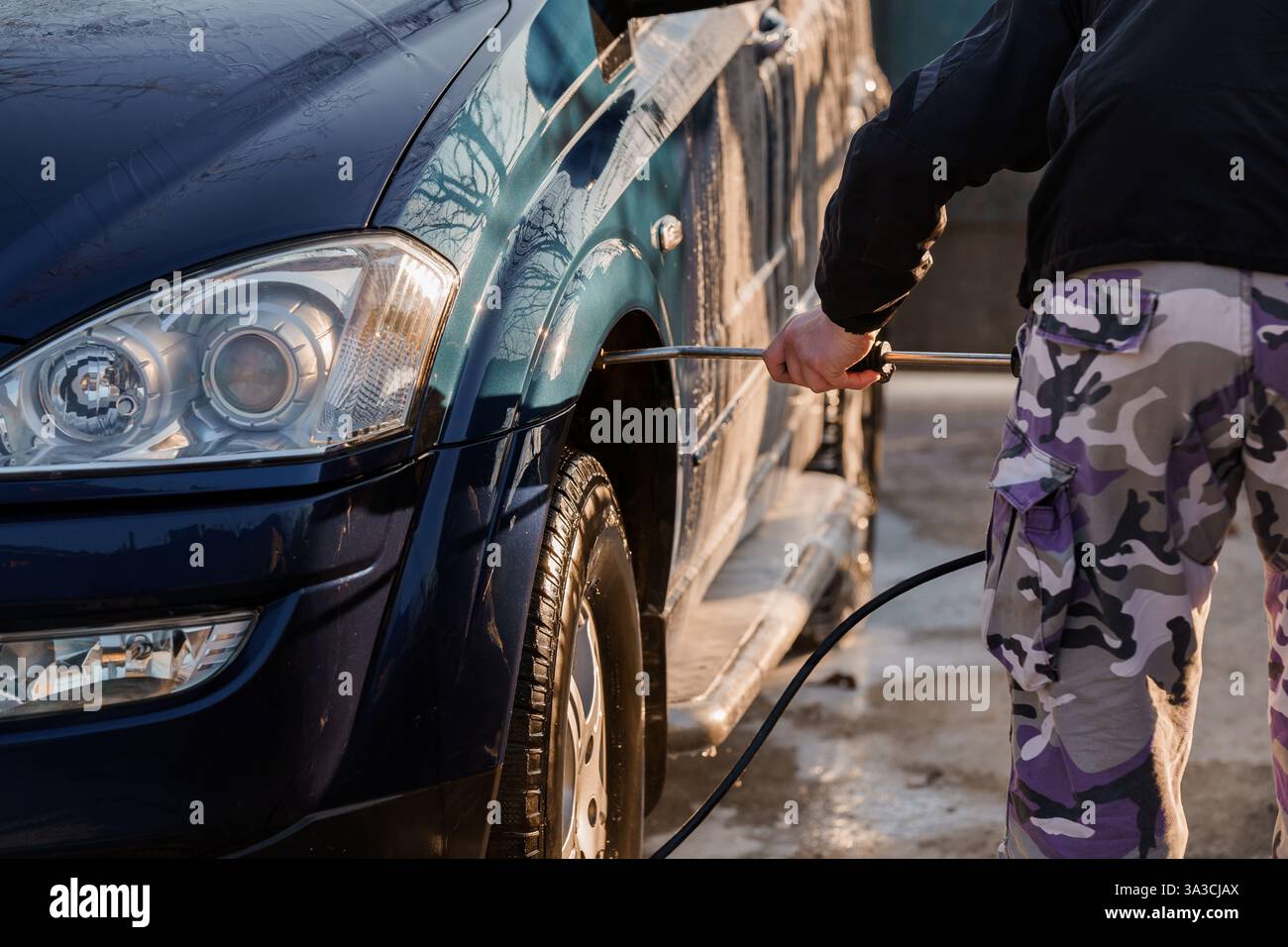 Person Washing Dark Blue SUV Car Using High Pressure Washer at Outdoor ...