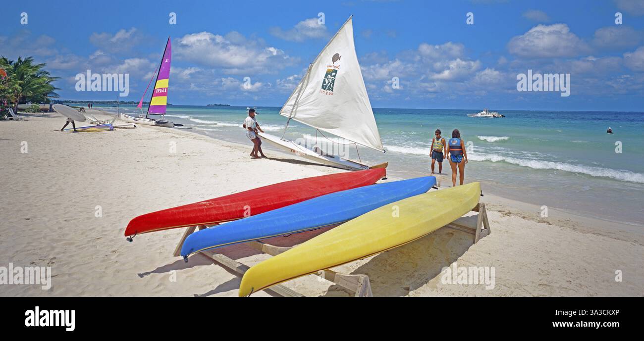 Negril beach, canoes, sailing boats, beach holidaymakers, water sports ...