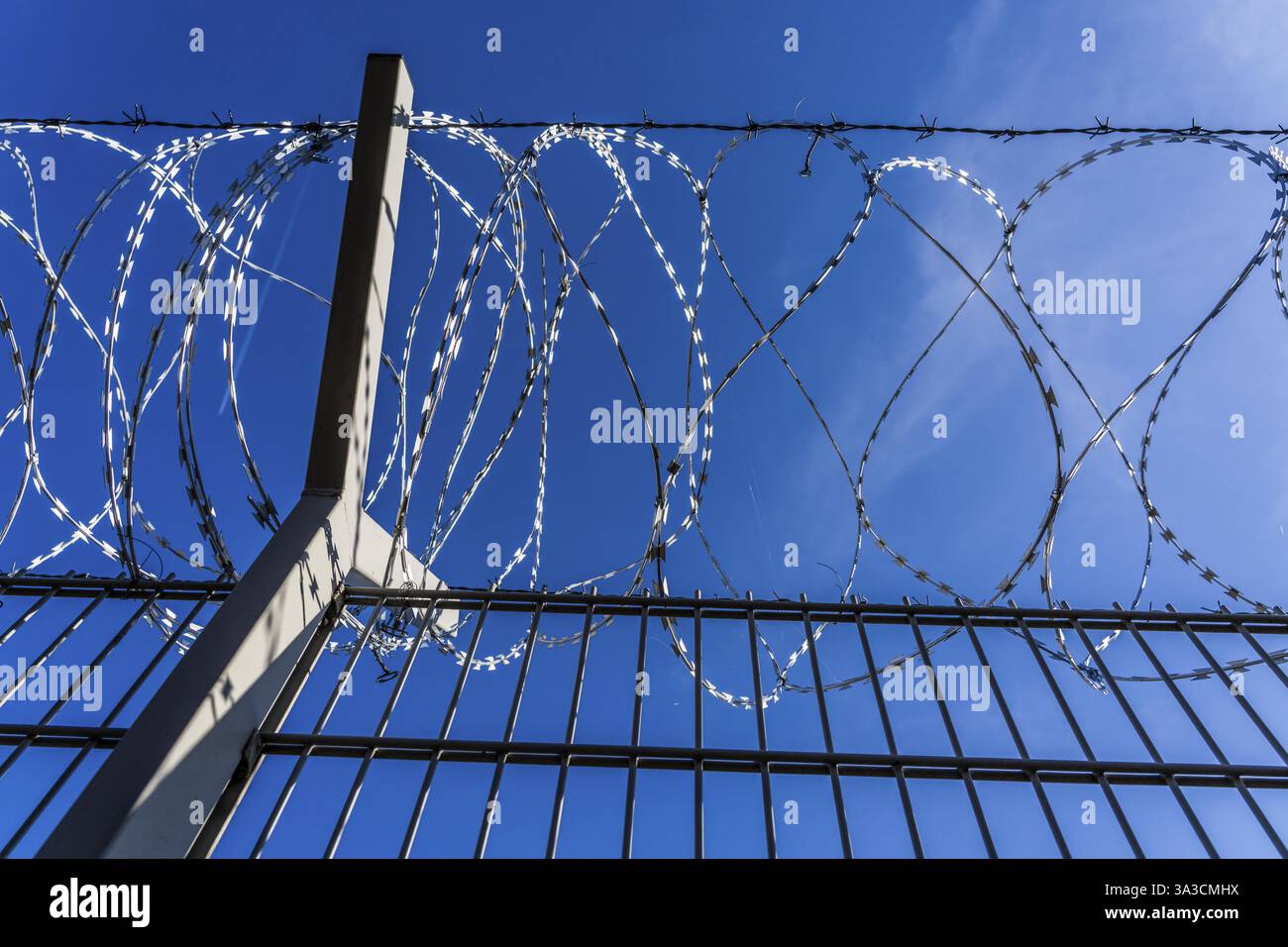 Symbolic image security, S-wire rolls, NATO wire, on a fence top ...