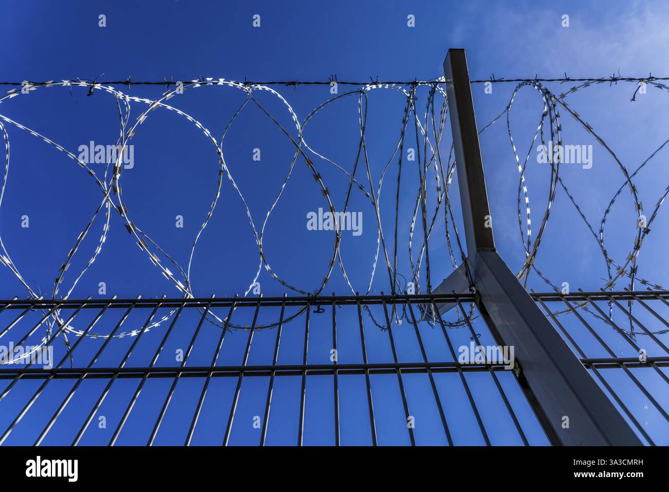 Symbolic image security, S-wire rolls, NATO wire, on a fence top ...