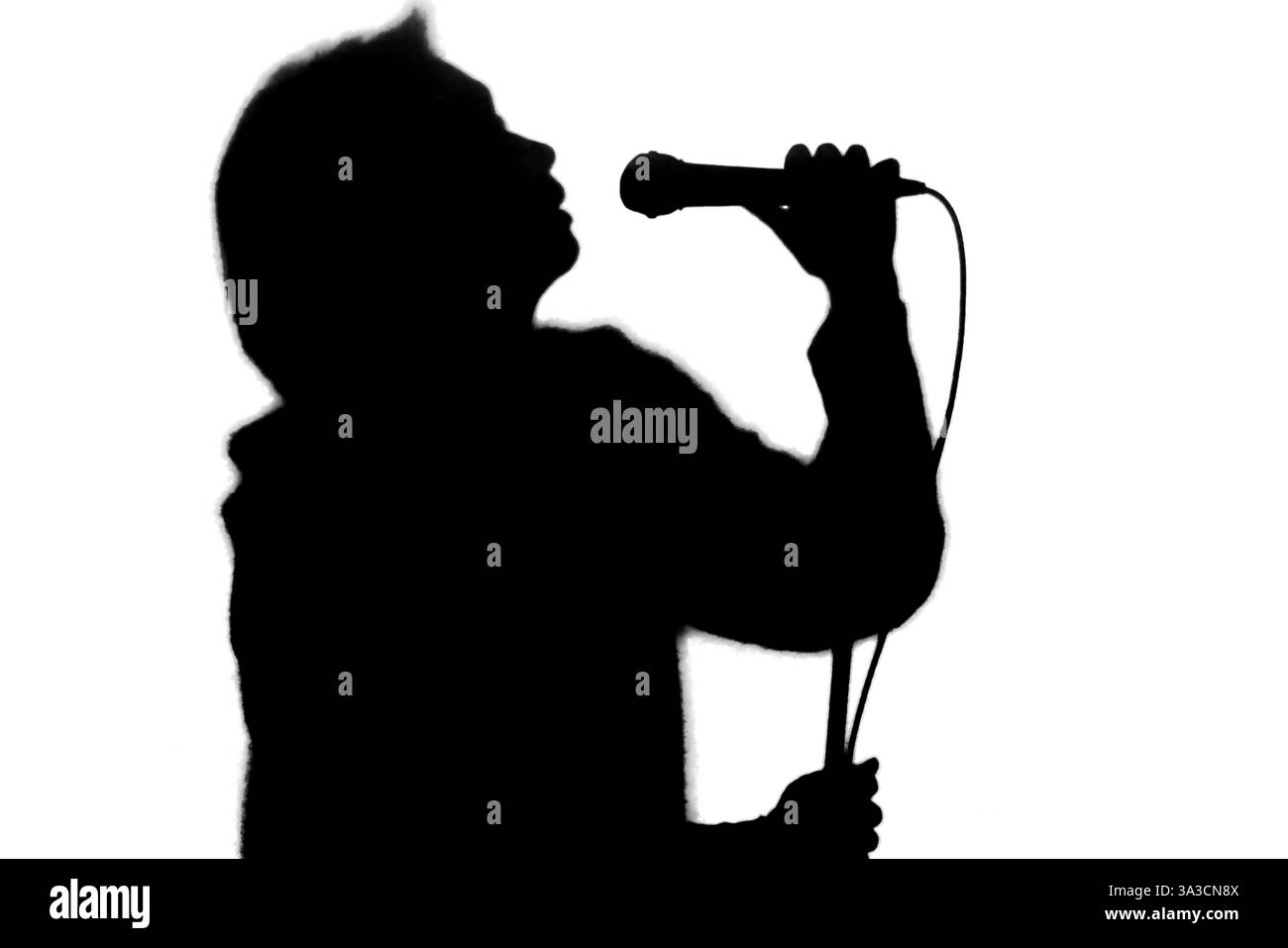 Person holding a microphone, depicted in silhouette, shadow image ...