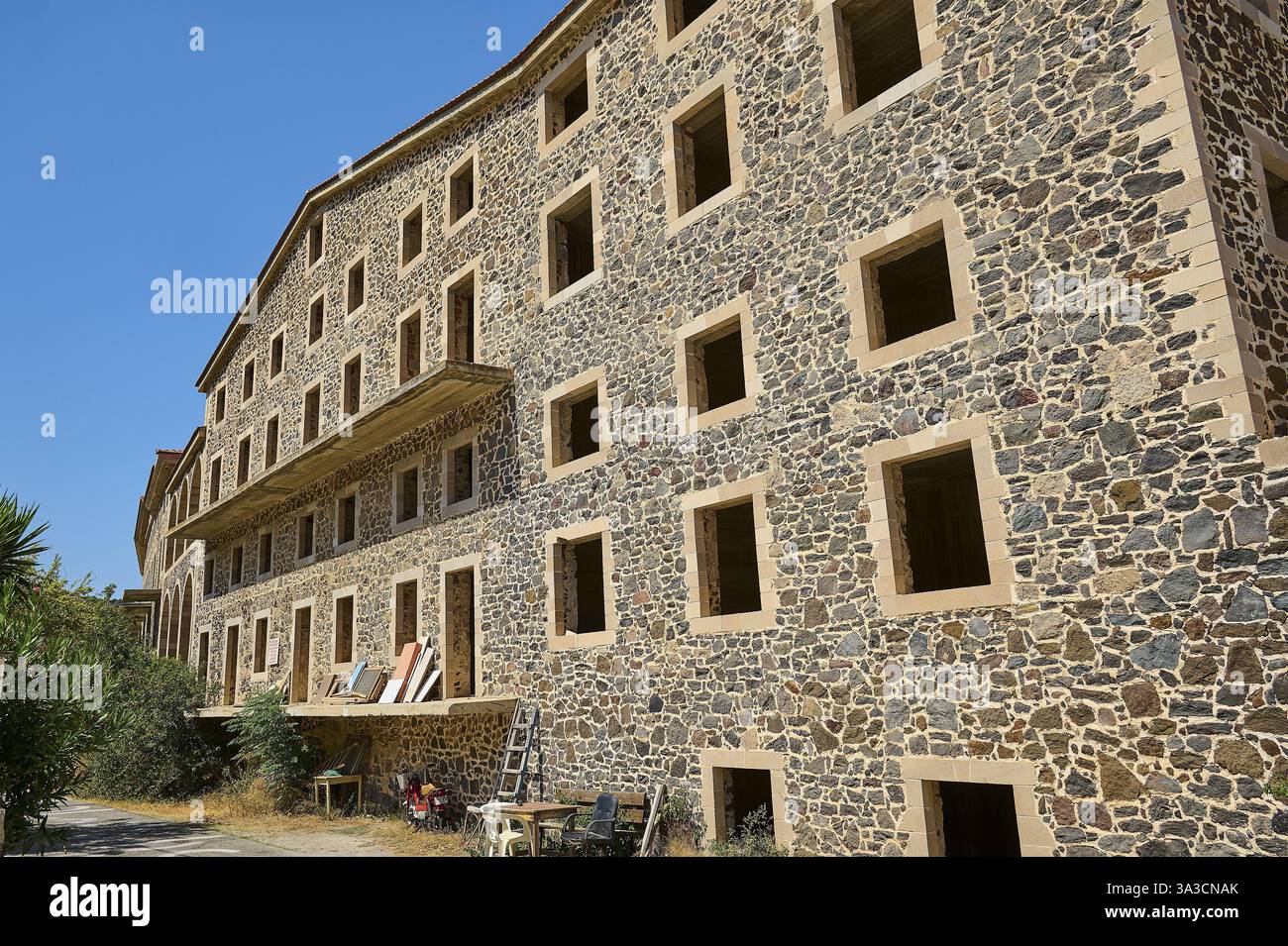 Abandoned building with numerous open windows in sunlight, ruins of a ...