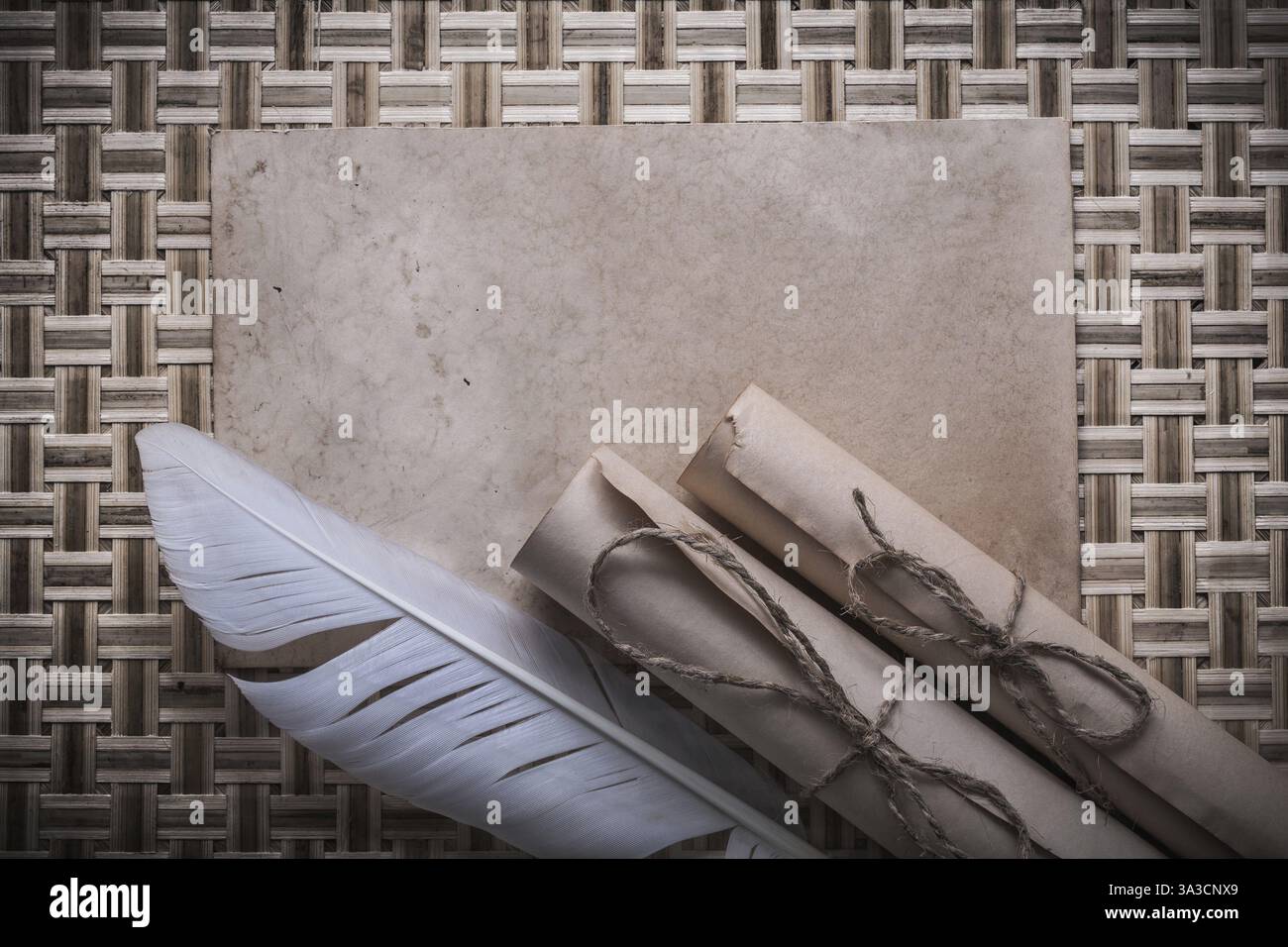 Vintage clean sheet paper scroll plume on woven wooden mat Stock Photo ...