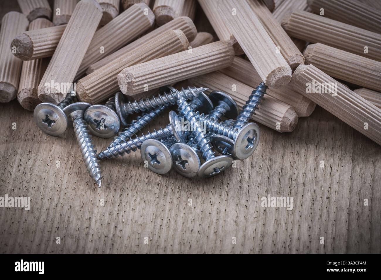 Woodworking dowels and construction nails on wood board top view Stock ...