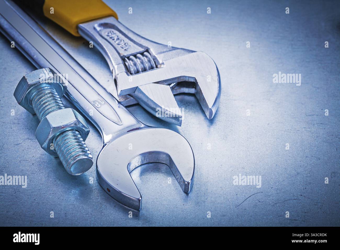 Stainless adjustable spanner open-end wrench bolt and nut on metallic ...