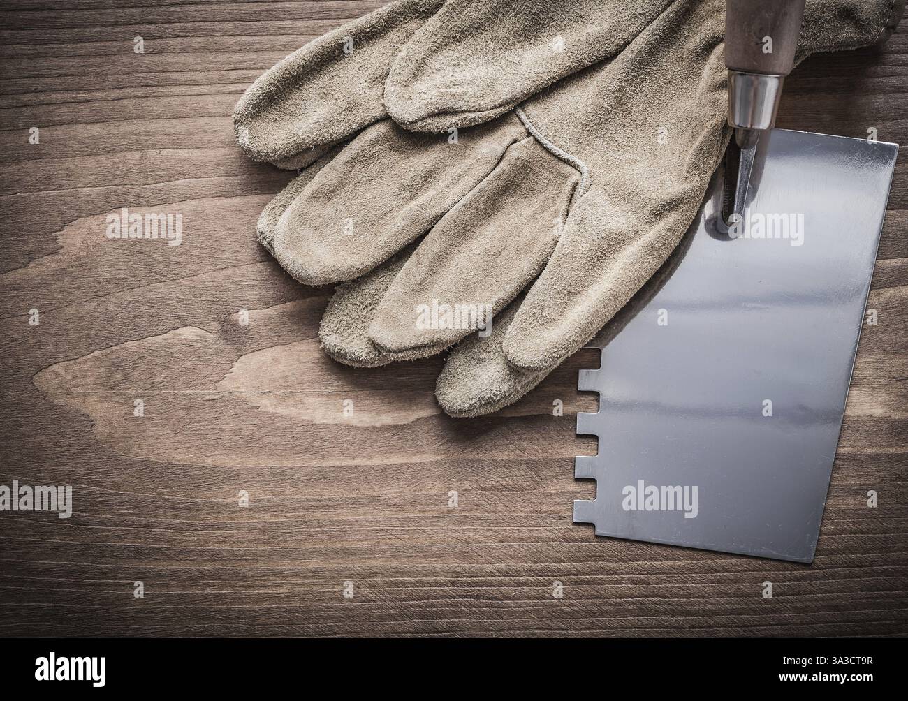 Working gloves and putty spattle on wood board Stock Photo - Alamy