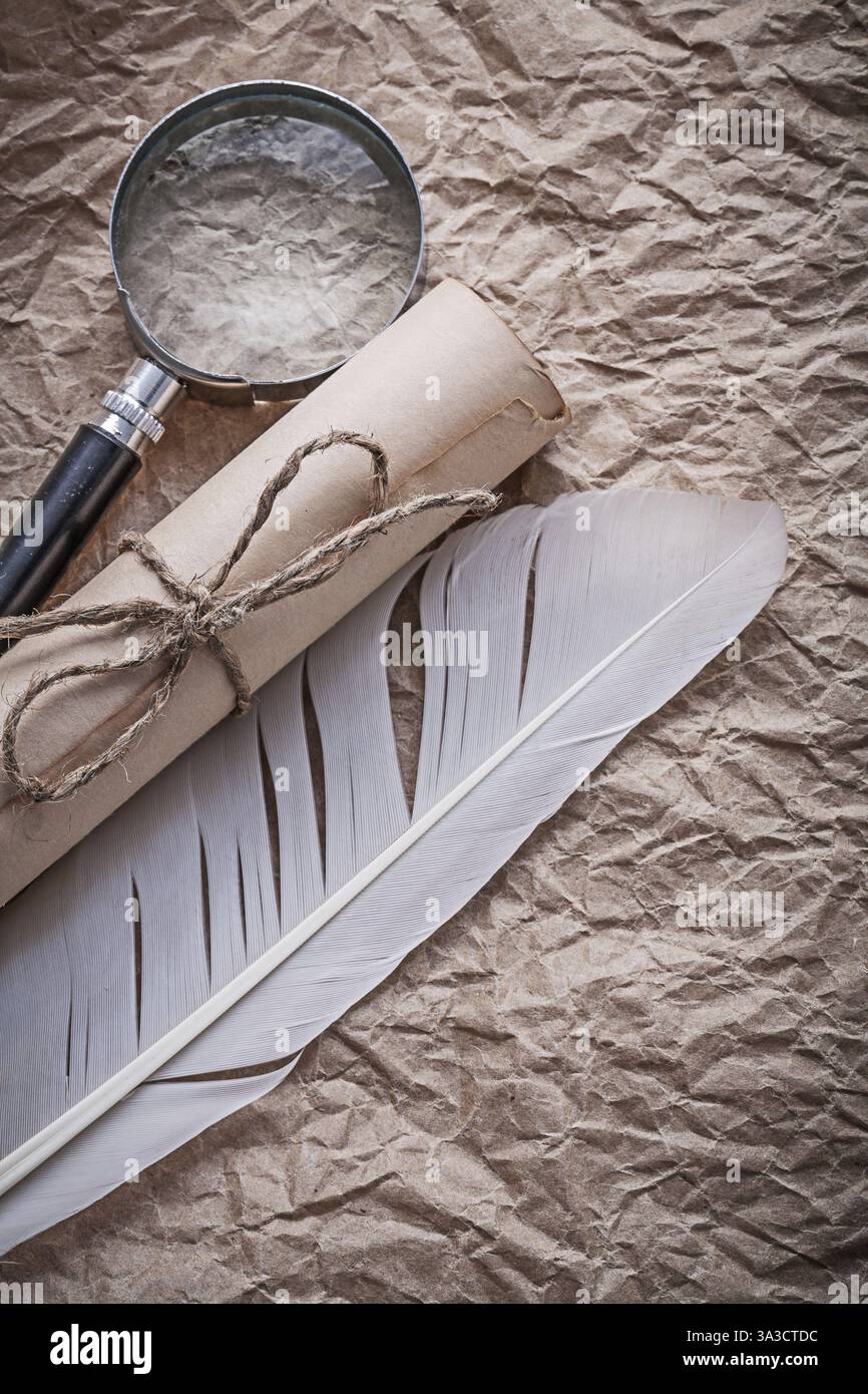 Vintage plume loupe corded rolled document on messy crumpled paper ...