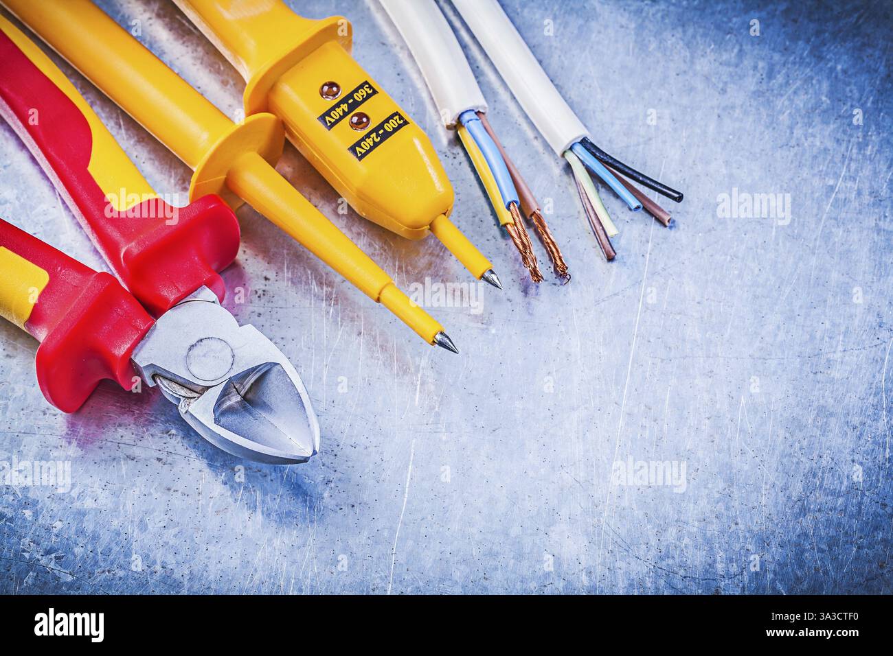 Yellow electrical tester wires wire cutter on metallic background ...