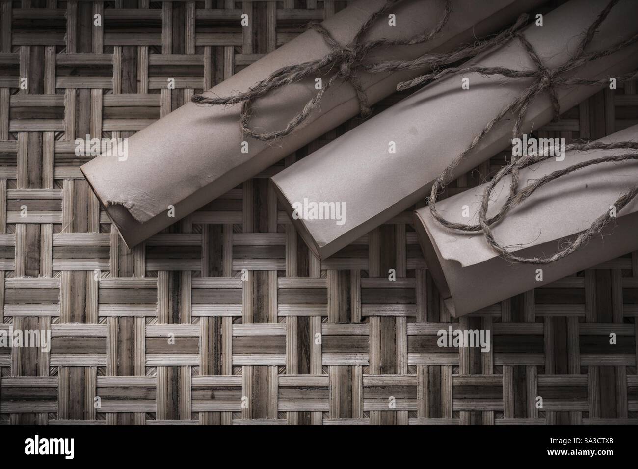 Vintage rolled scrolls on woven wooden mat Stock Photo - Alamy