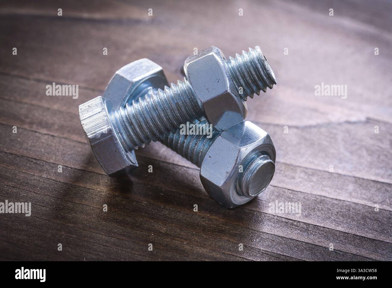 Vintage wooden board with couple of metal threaded bolts and screw nuts ...