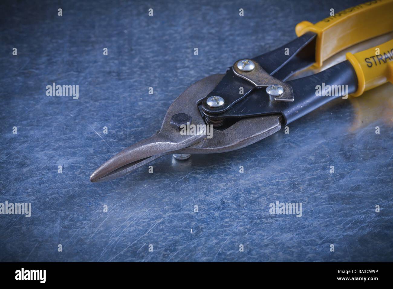 Tin snips on scratched vintage metallic background construction concept ...
