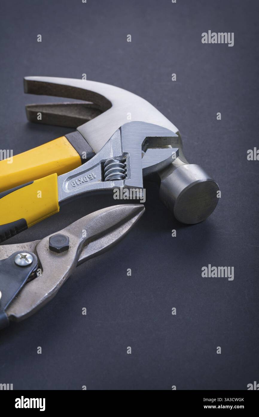 Vertical view adjustable wrench claw hammer steel cutter on black ...