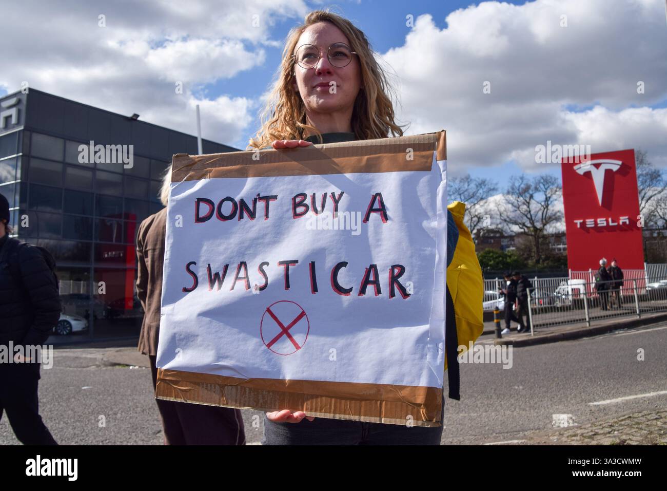 London, UK. 15th March 2025. A protester holds a sign urging people not ...