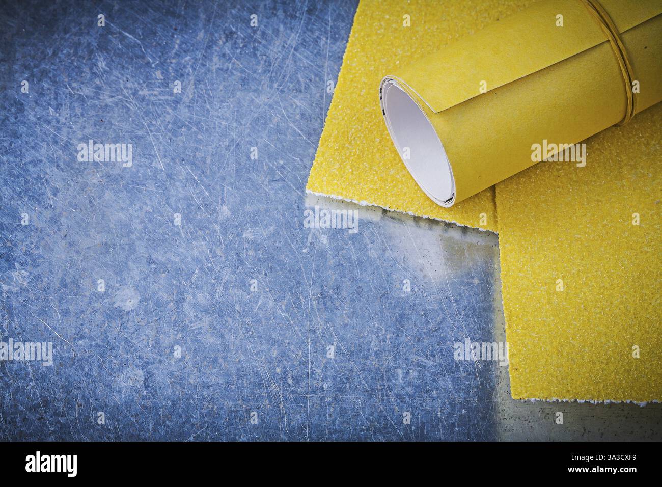 Yellow sandpaper on scratched metallic background abrasive materials ...