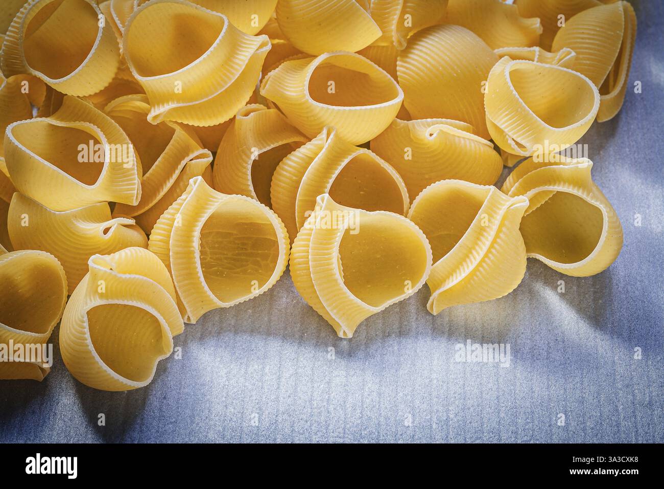 Stack of uncooked shell macaroni on blue background food and drink ...