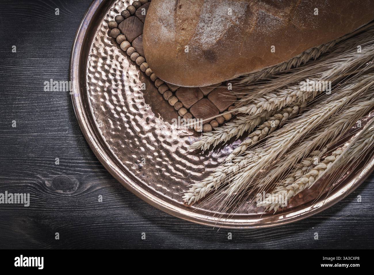 Vintage copper tray with loaf of baked rye bread wheat-rye ears on ...