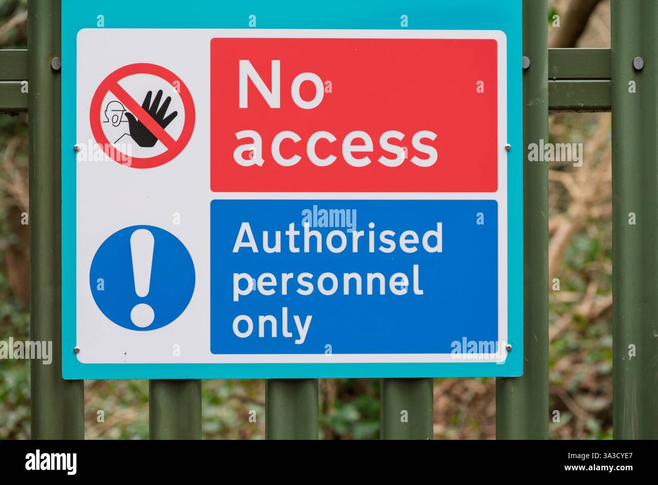 The image shows a "No access, authorised personnel only" sign attached to a green metal fence ...