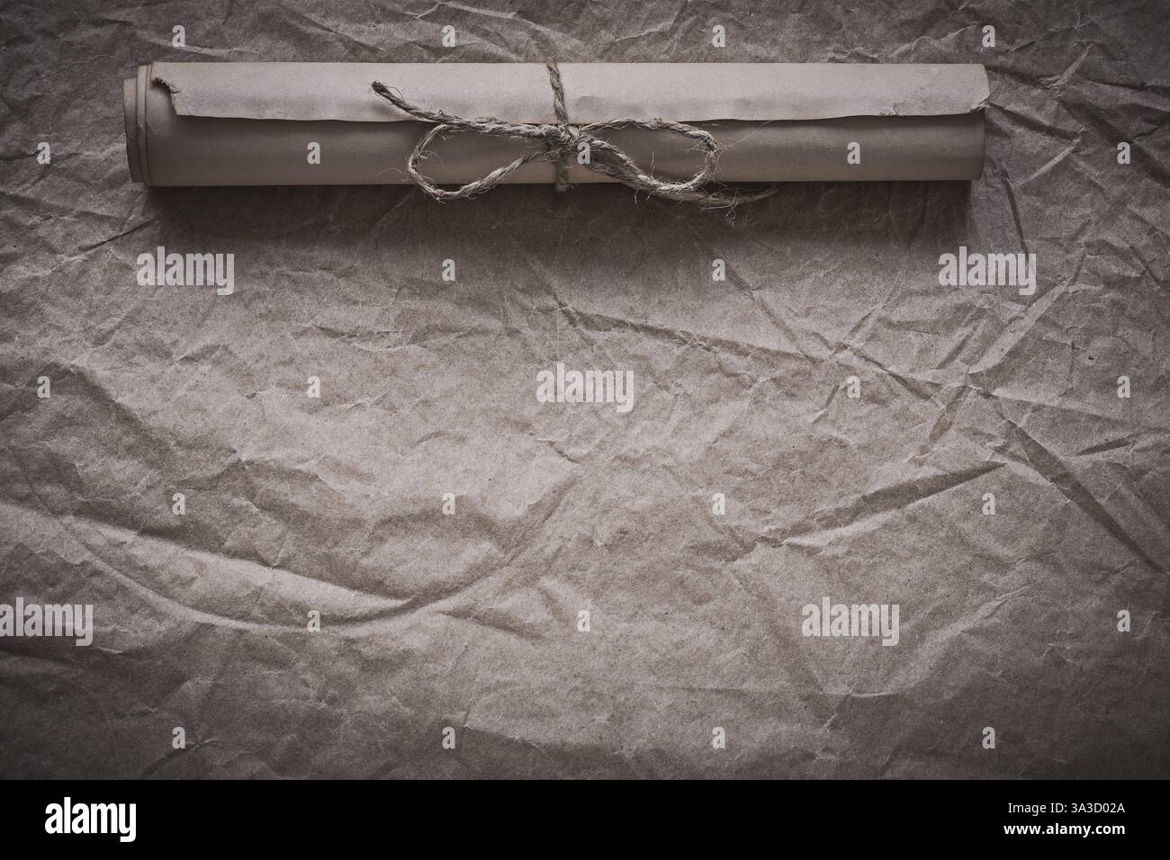 Vintage paper roll on crumpled wrapping sheet Stock Photo - Alamy