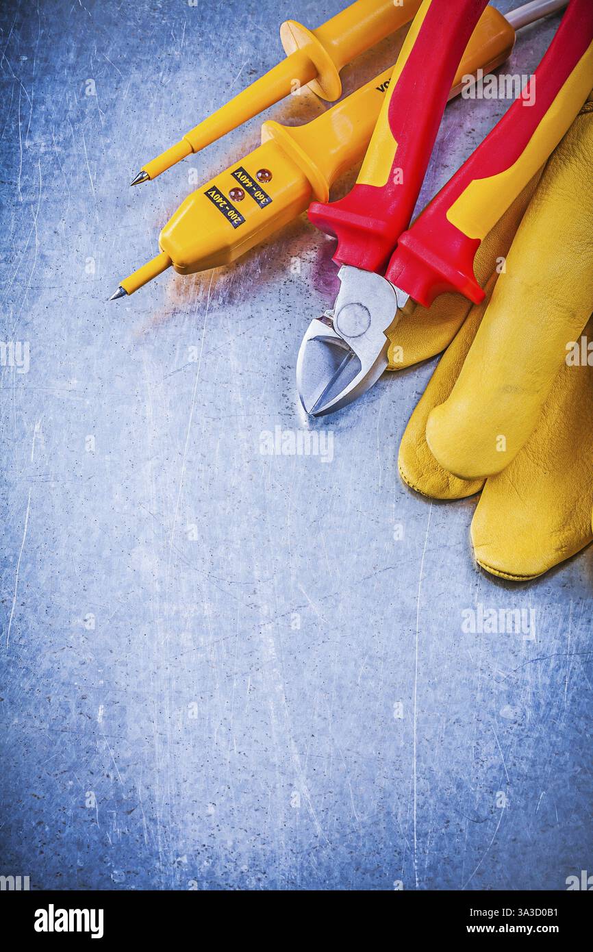 Yellow electrical tester safety gloves sharp wire cutter on metallic ...