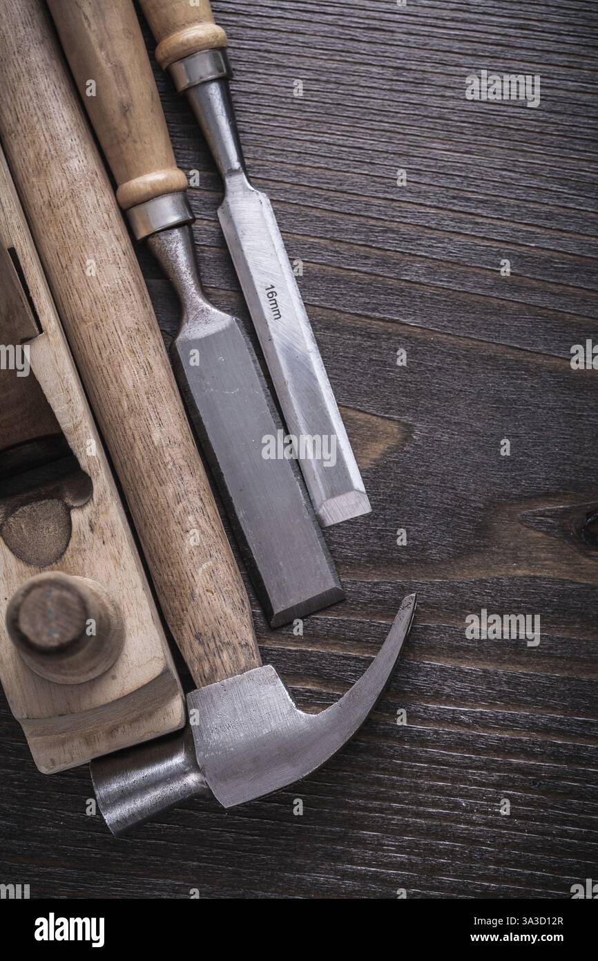 Vertical view of claw hammer wooden planer and flat chisels on vintage ...