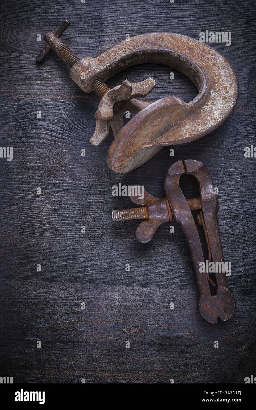 Two old clamps on vintage wood board Stock Photo - Alamy
