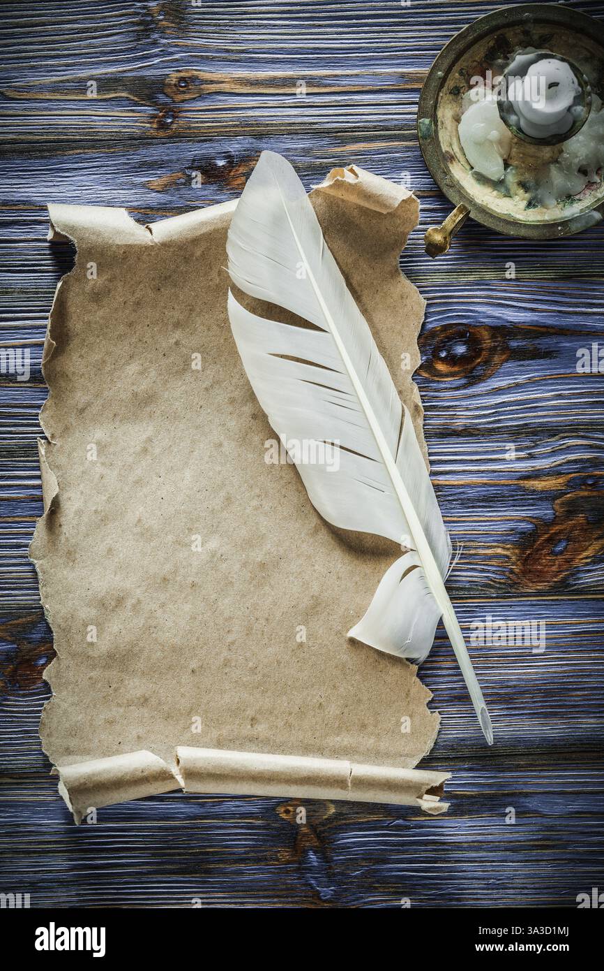 Vintage paper roll feather candlestick on blue wooden background Stock ...
