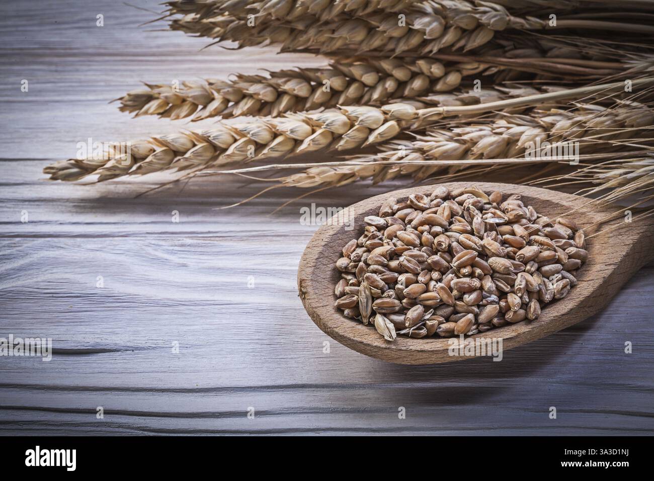 Wheat rye ears corn wooden spoon on wood board Stock Photo - Alamy