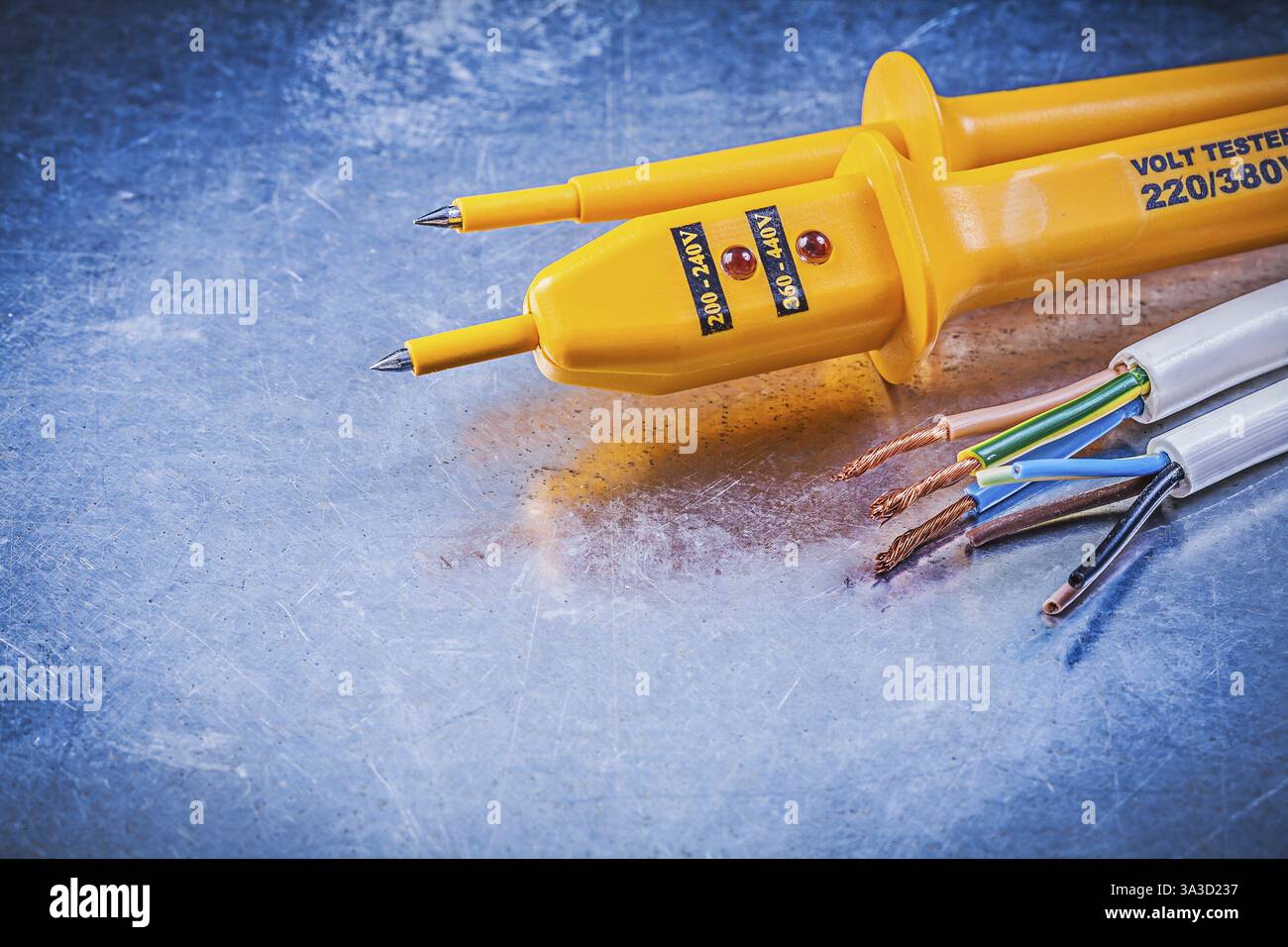 Yellow electrical tester wires on metallic background electricity ...