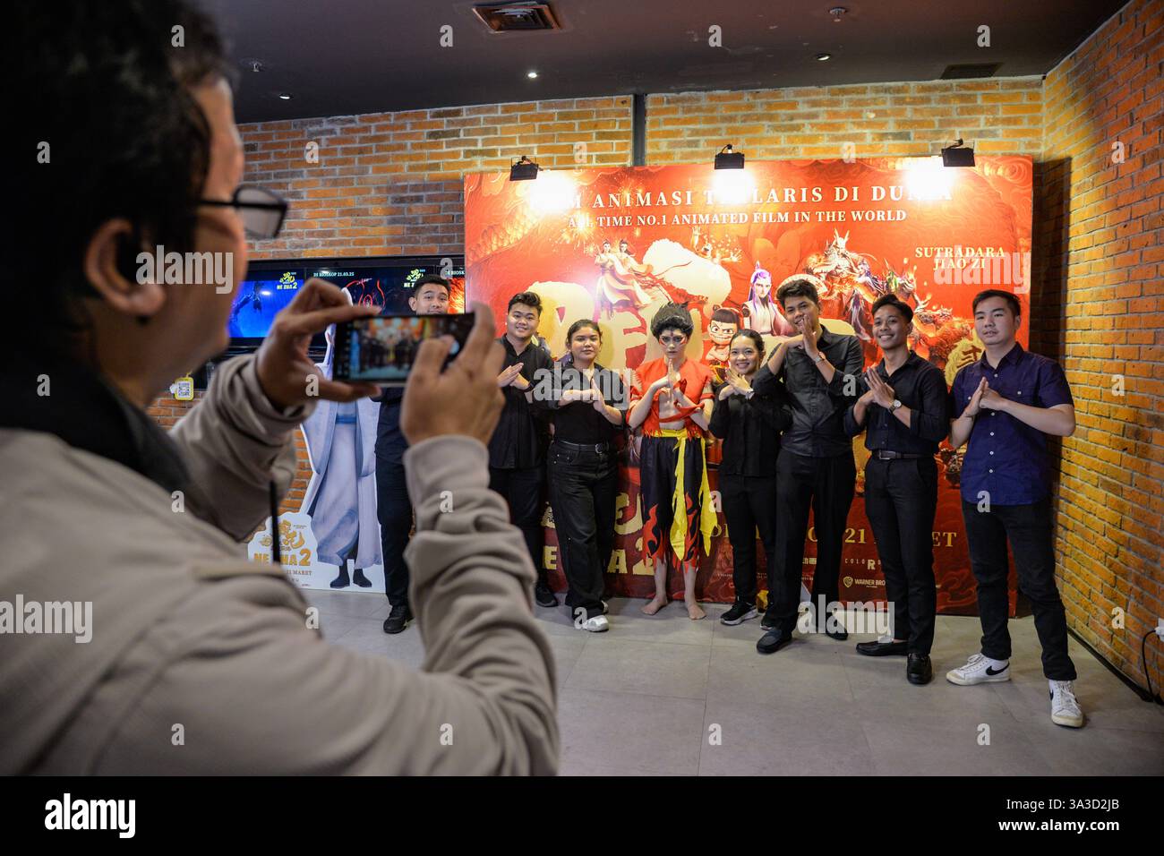 Jakarta, Indonesia. 15th Mar, 2025. People pose for photos in front of a poster of Chinese ...