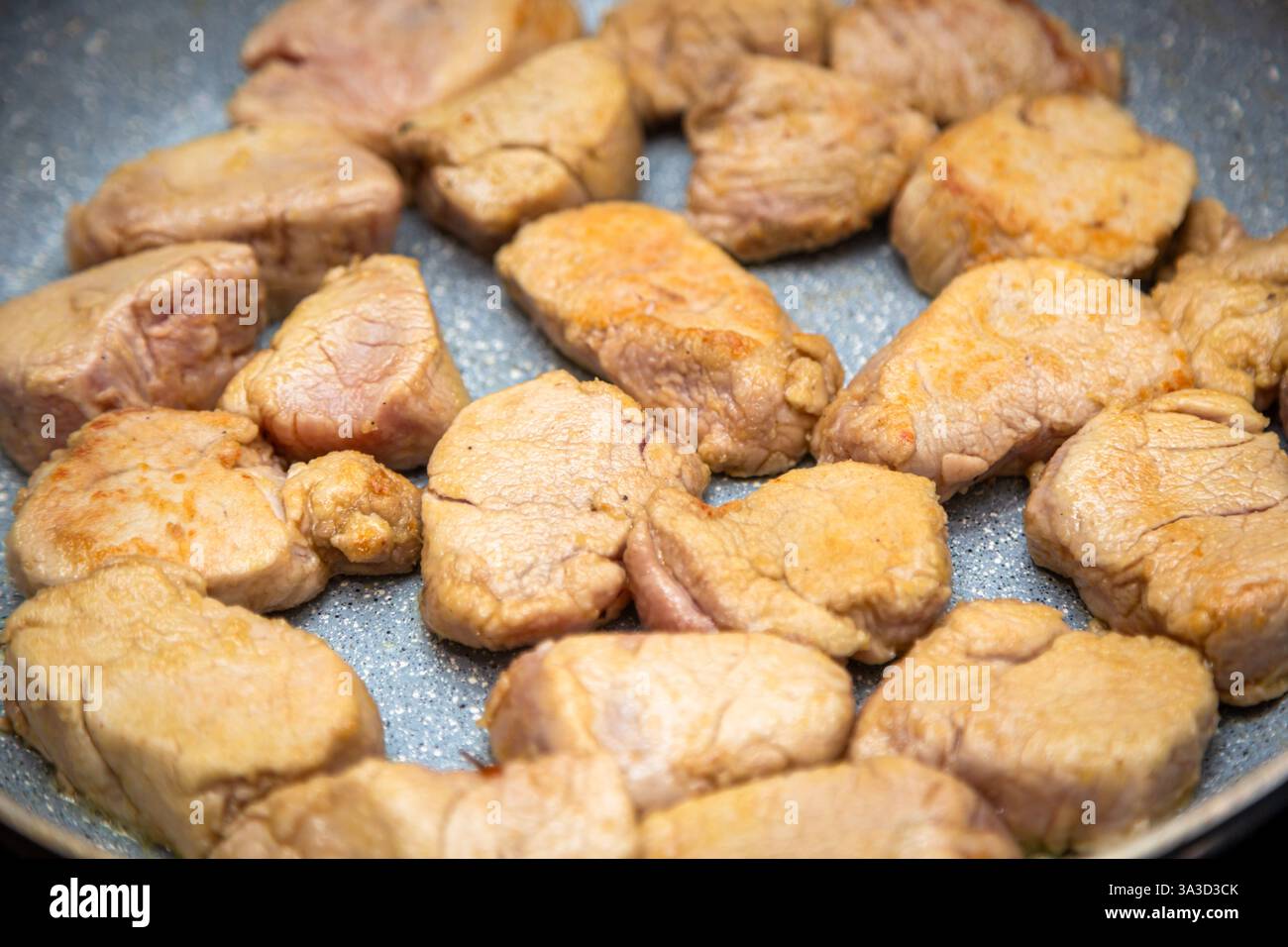 Pork pieces in frying pan Stock Photo - Alamy