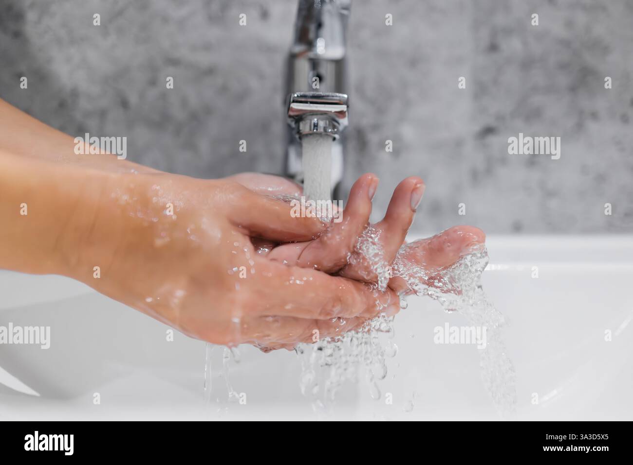 Close-up of hands washing under running water, symbolizing the ...