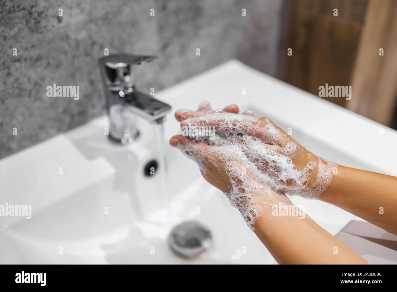 A close-up of hands washing their hands with soap emphasizes hygiene ...
