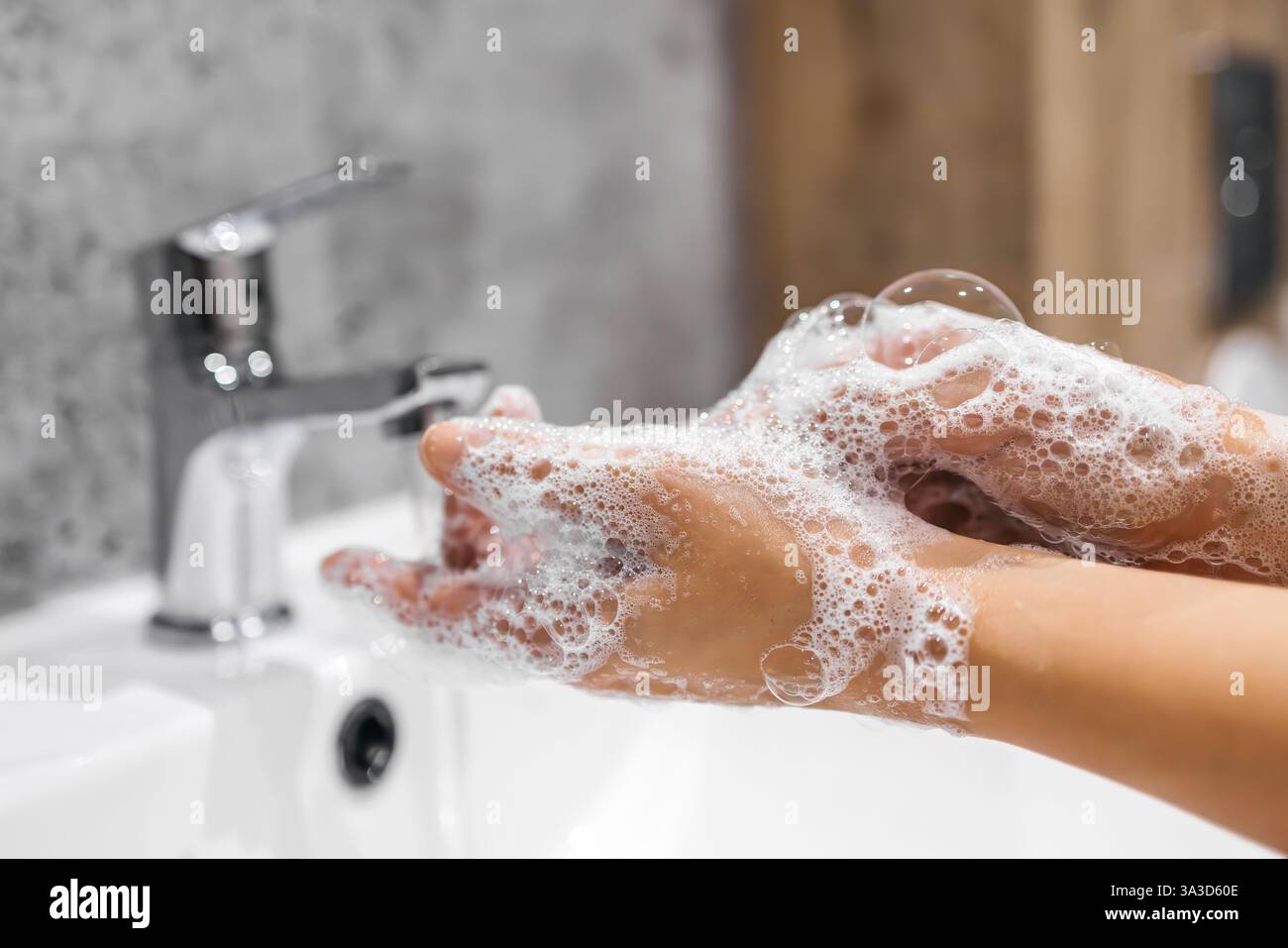A close-up of hands washing their hands with soap emphasizes hygiene ...