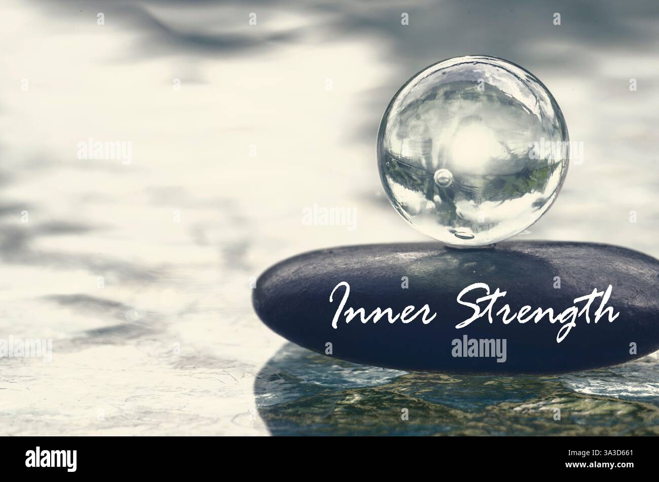 Inner Strength text on zen stone with bright shining glass marble ...