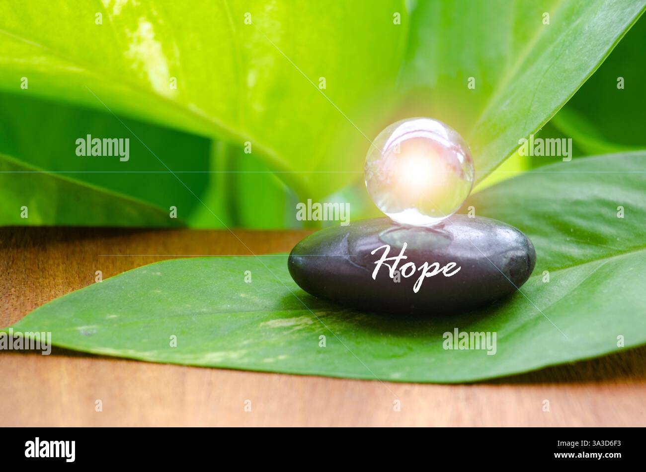 Hope text on zen stone with bright shining glass marble. Hope concept ...