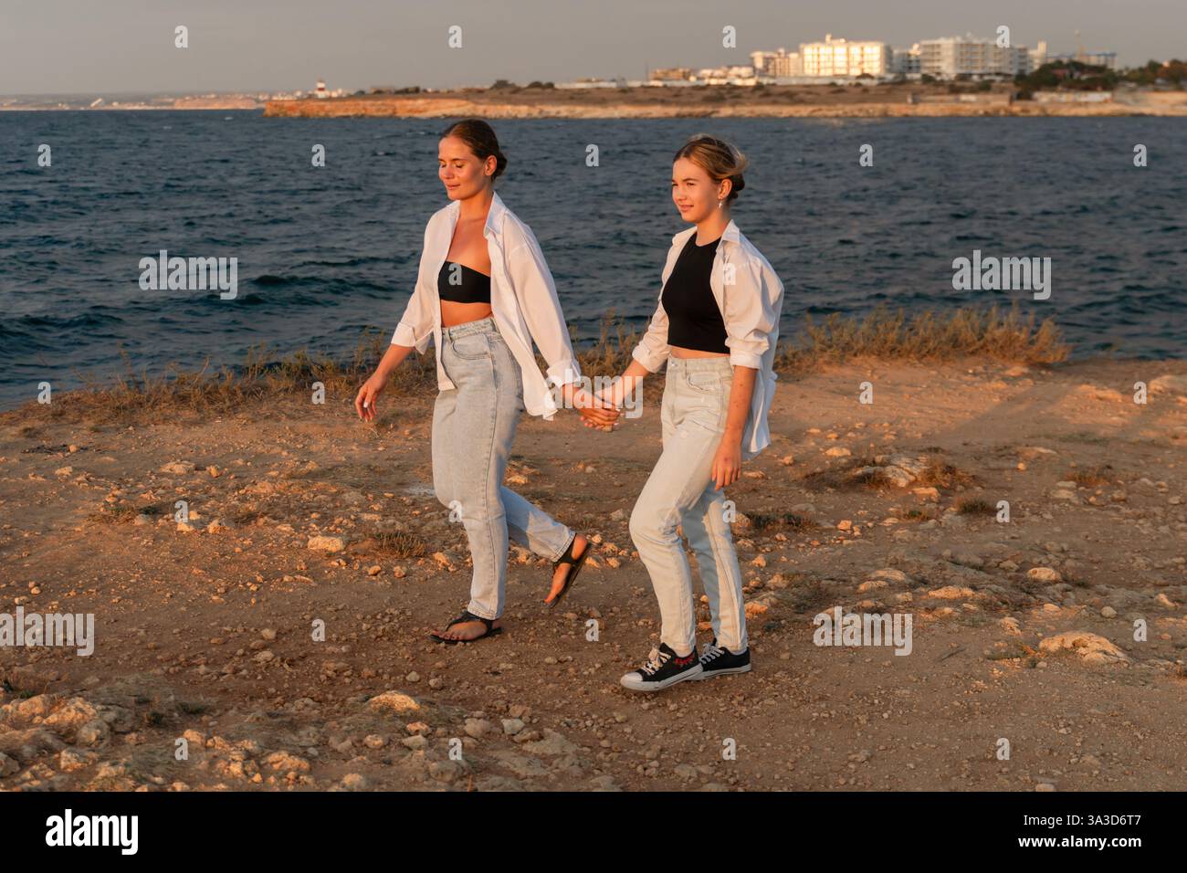 Twins Beach Sunset Walk Holding Hands Stock Photo - Alamy