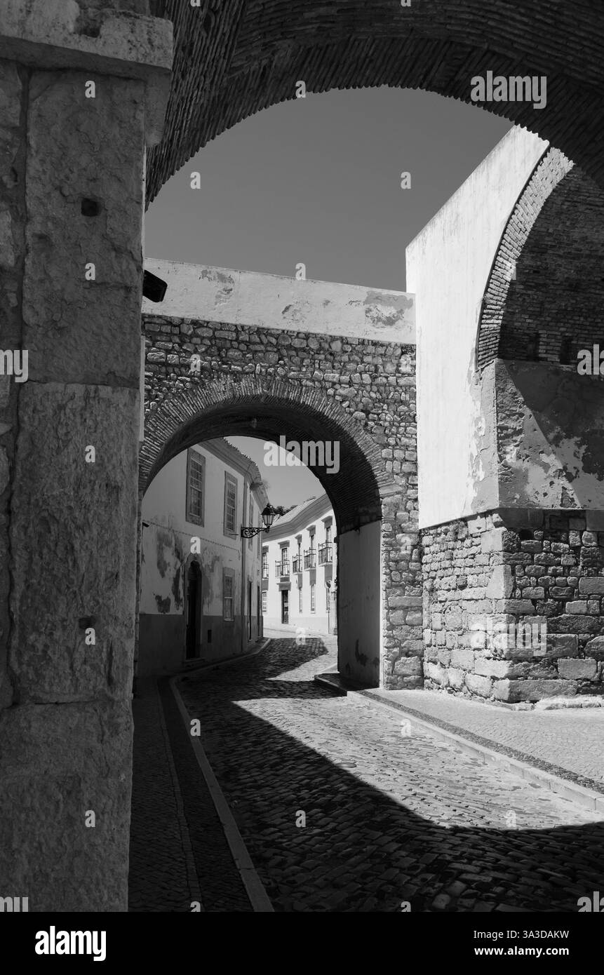 Elegant archway of Arco do Repouso in Faro, Algarve, Portugal, blending ...