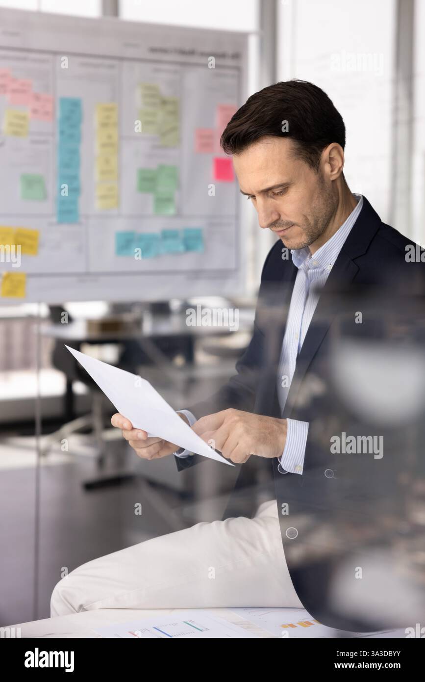 Serious Hispanic company boss, CEO man reading paper letter Stock Photo ...