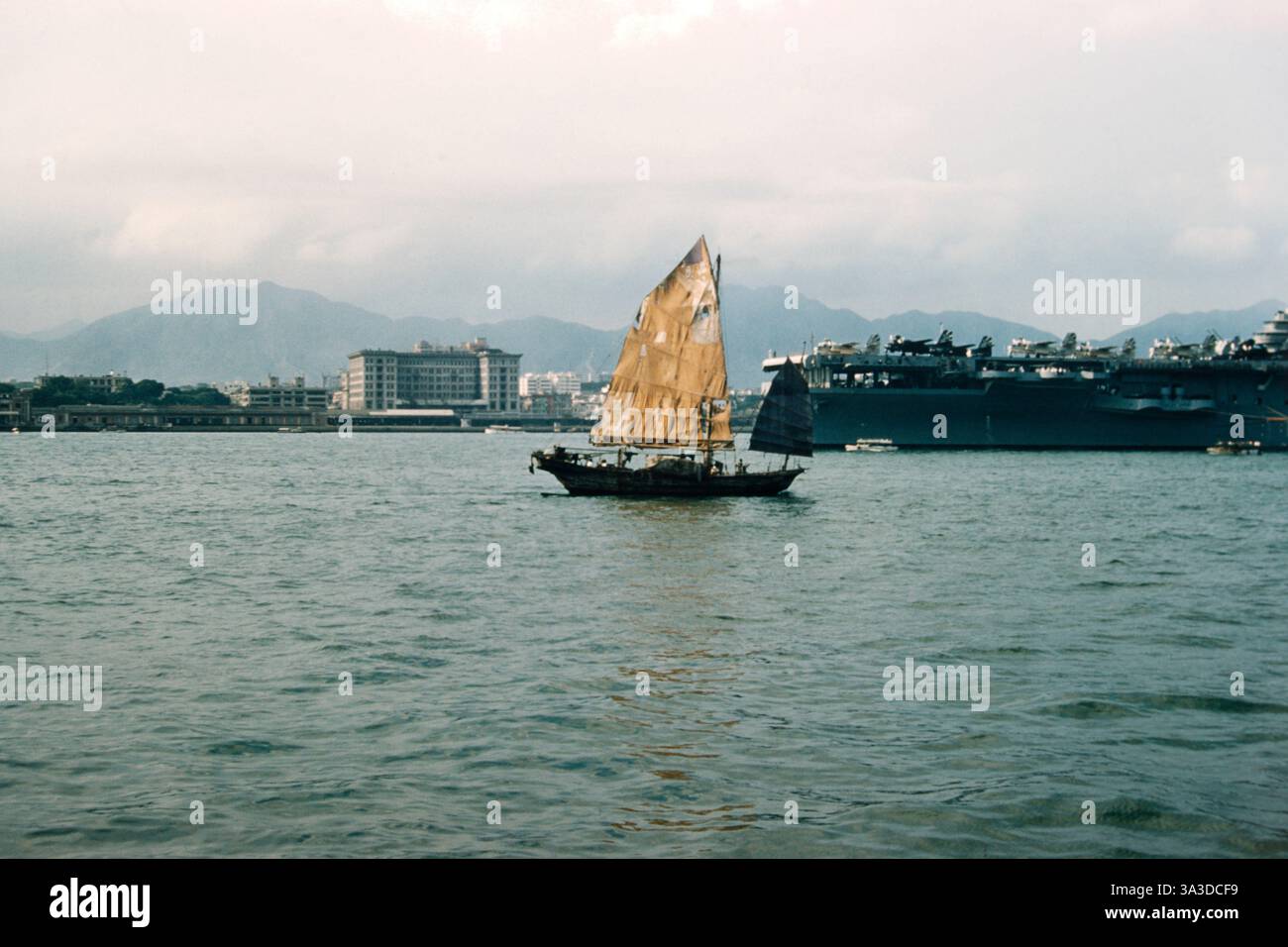 Chinese junk sailing in front of aircraft carrier, 1950's Stock Photo ...