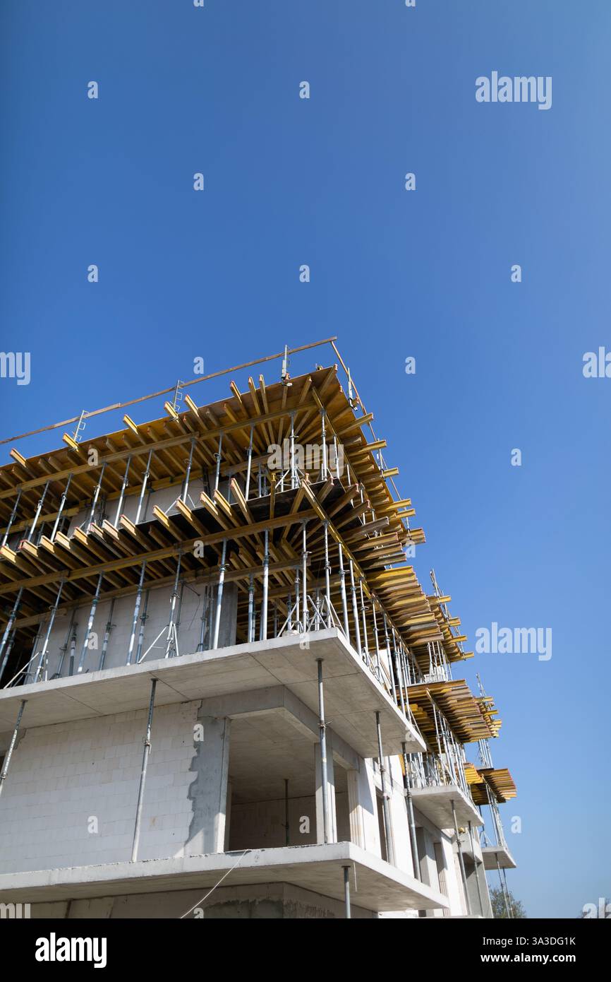 A construction site thrives under a blue sky, showcasing architecture ...