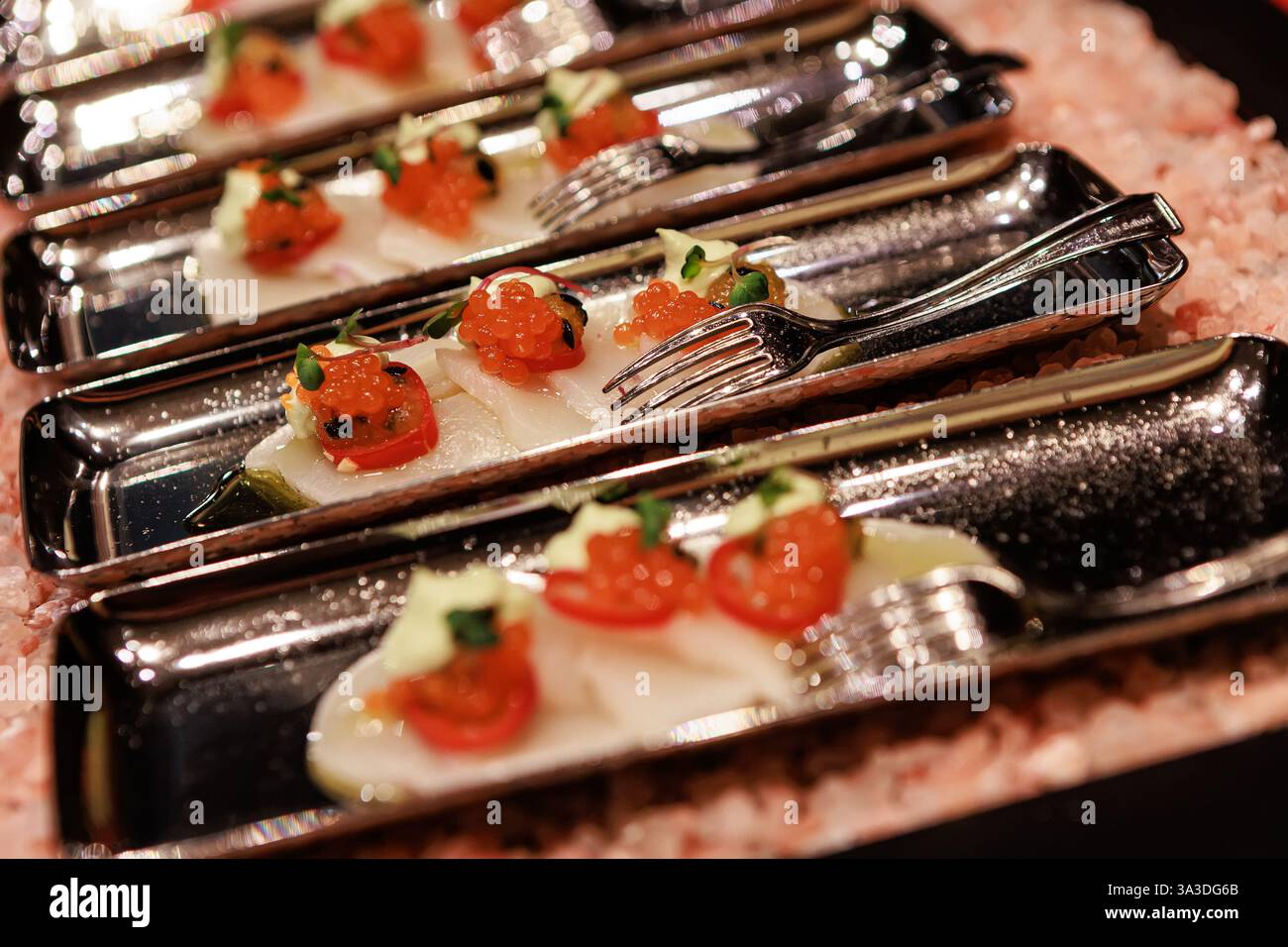 Elegant seafood appetizer featuring thinly sliced scallops, garnished ...