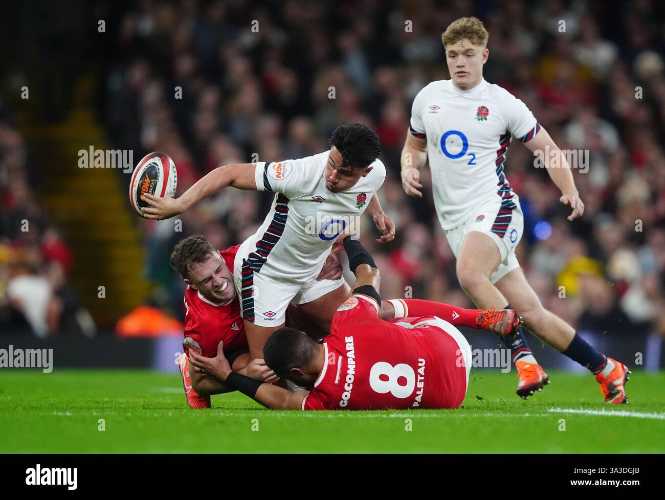 England's Marcus Smith (centre) is tackled by Wales' Max Llewellyn ...
