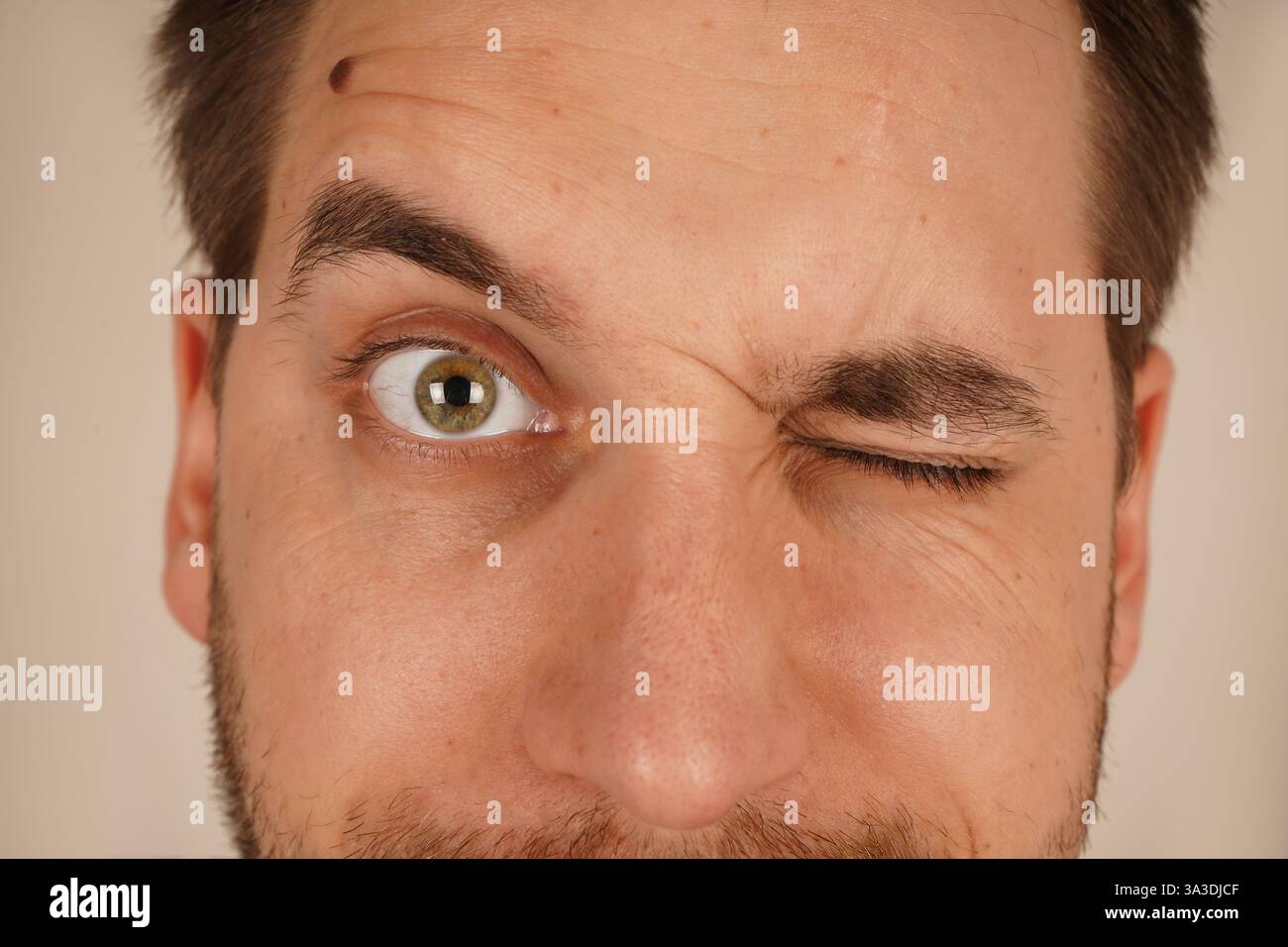 In this close-up, a young man s face displays a disgusted expression ...