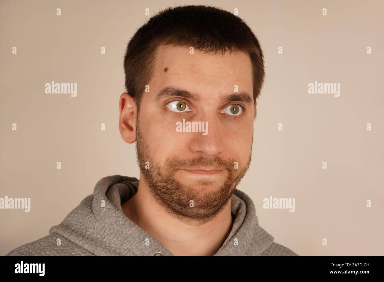 In this close-up, a young man s face displays a disgusted expression ...