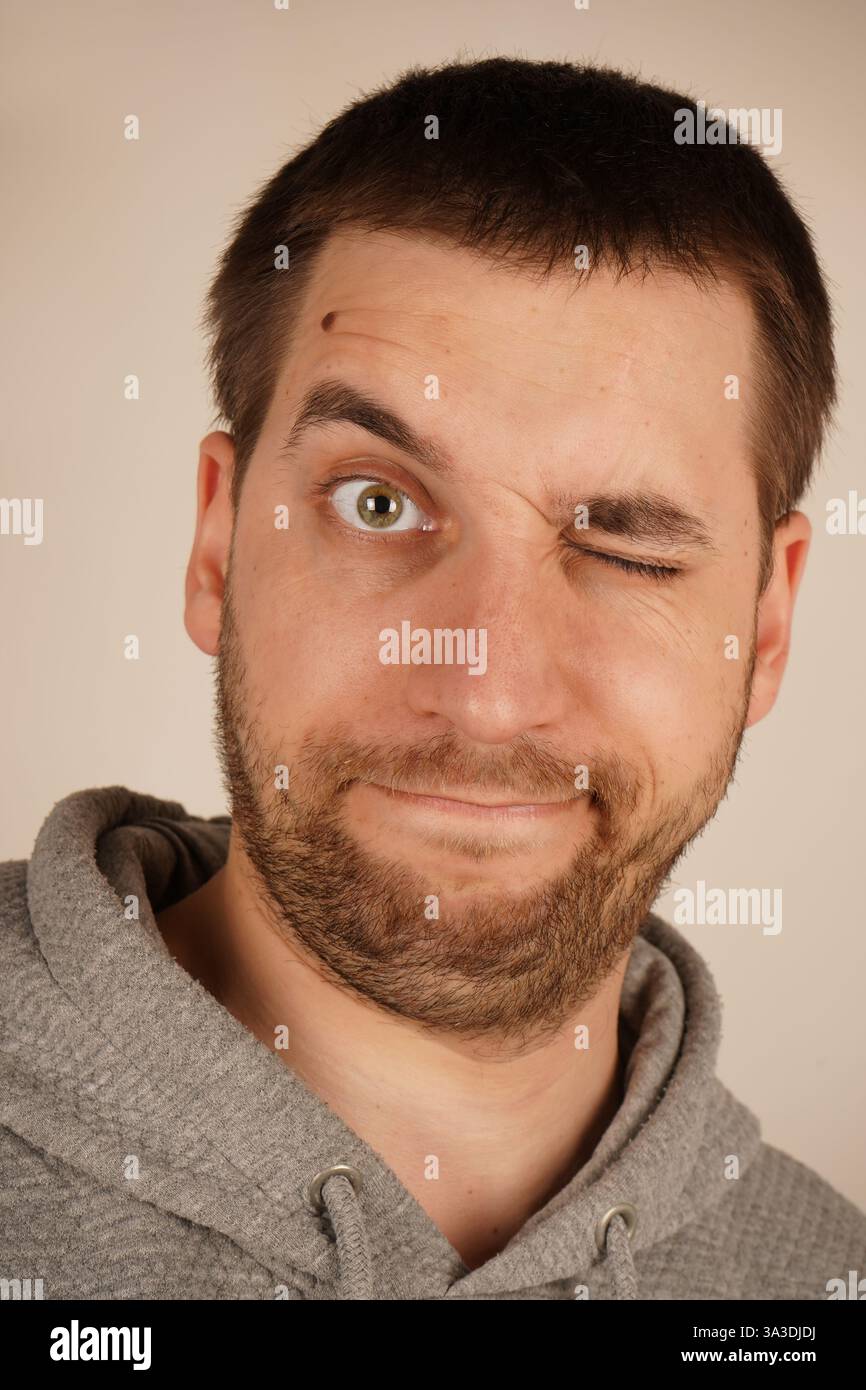 In this close-up, a young man s face displays a disgusted expression ...